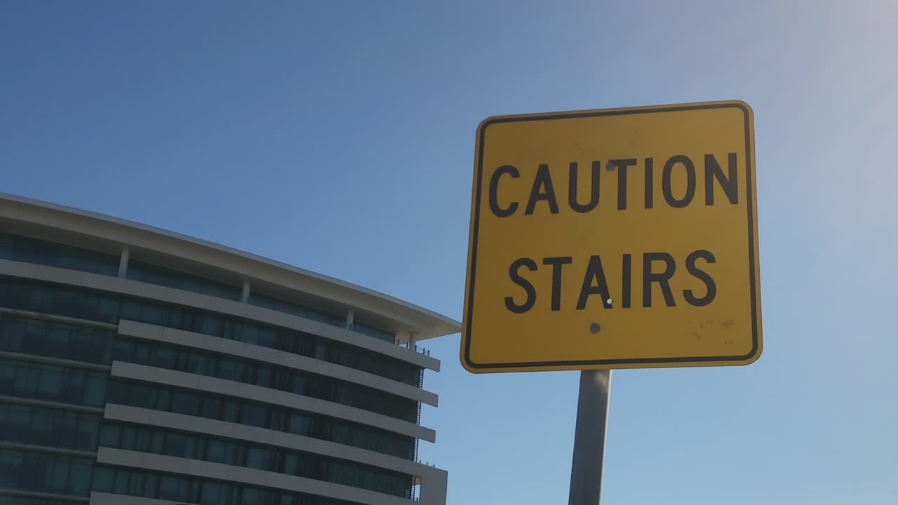 Premium stock video - Yellow caution stairs warning sign