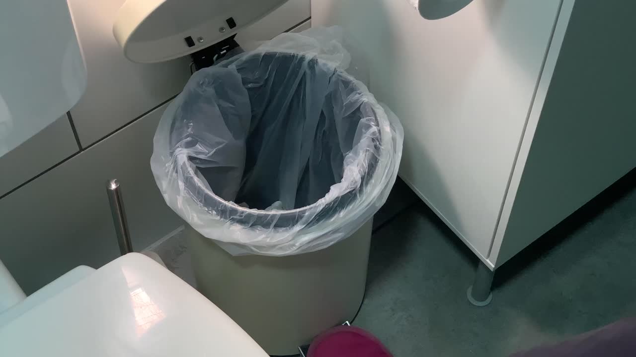 Premium stock video - Throwing handkerchief trash into garbage in bathroom