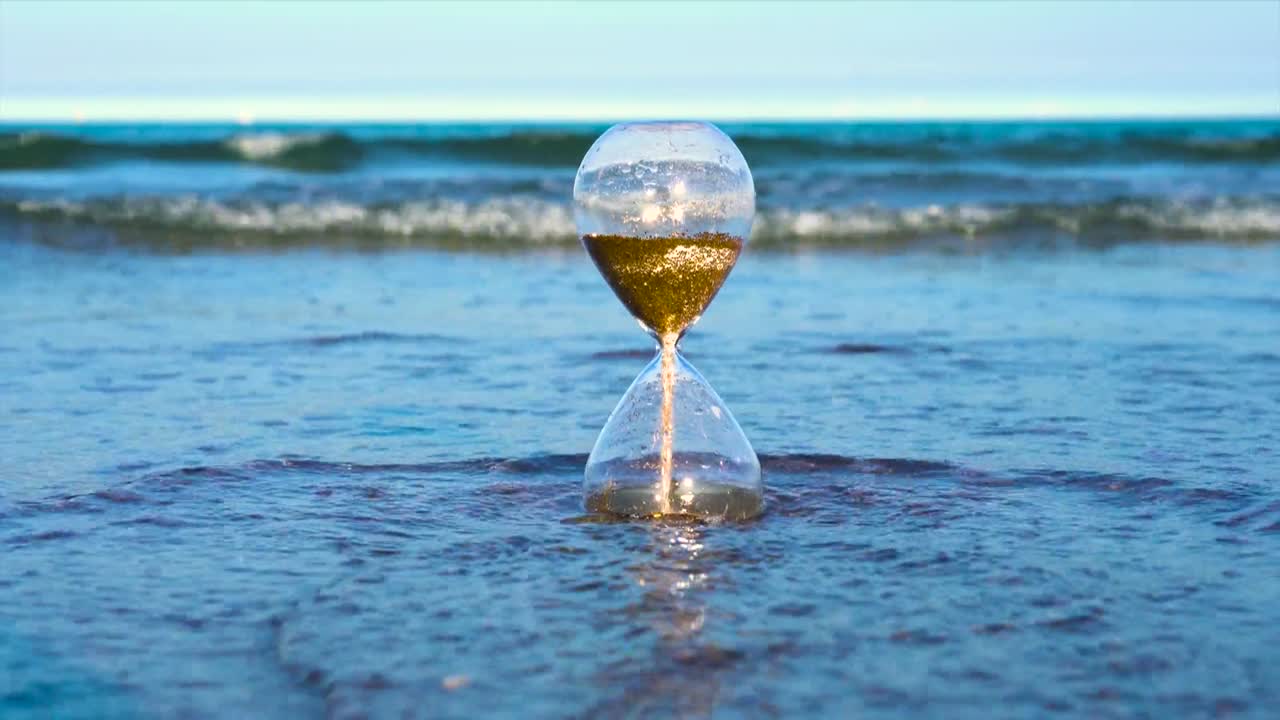 Premium stock video - Hourglass filled with sand on the beach, time out ...