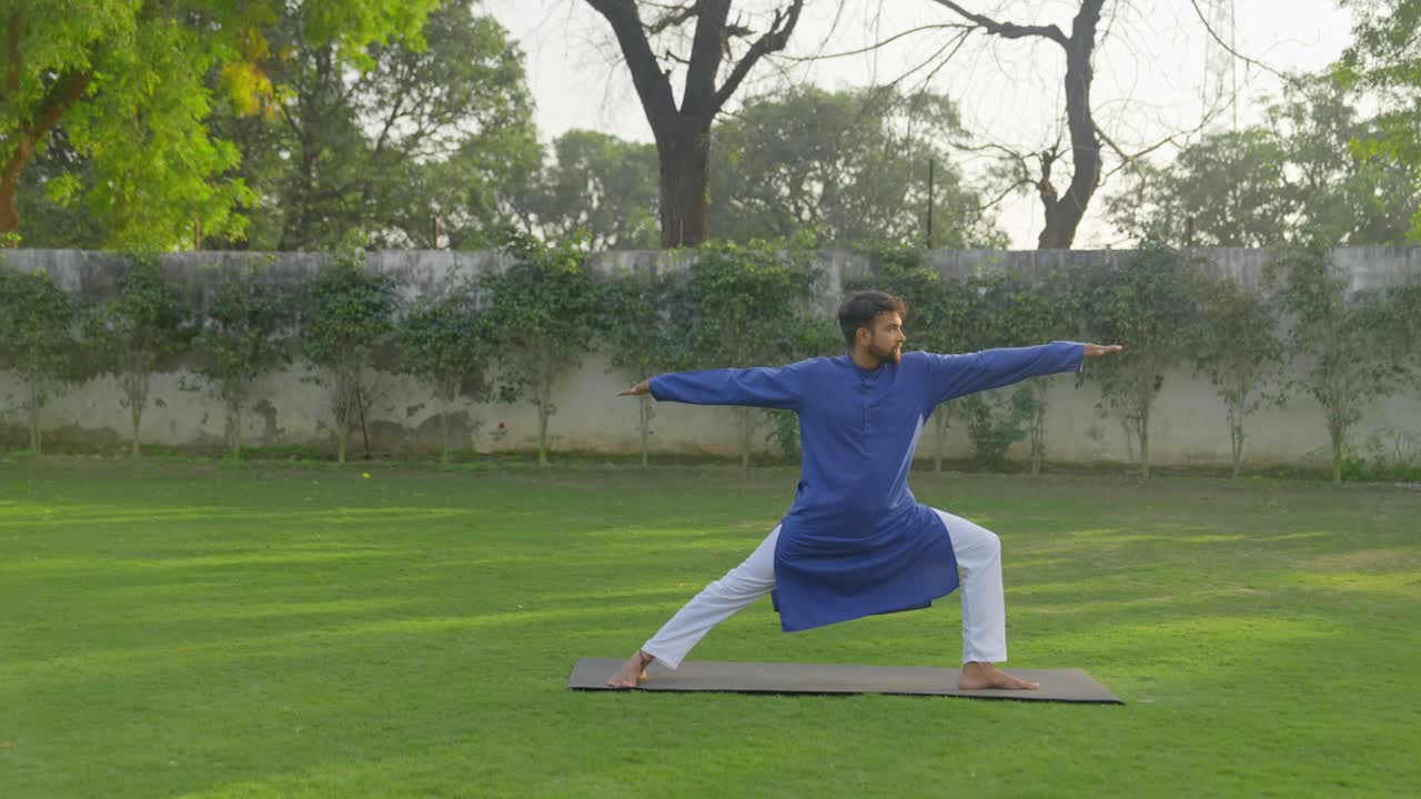 Indian man doing warrior yoga pose Premium Stock Video Footage