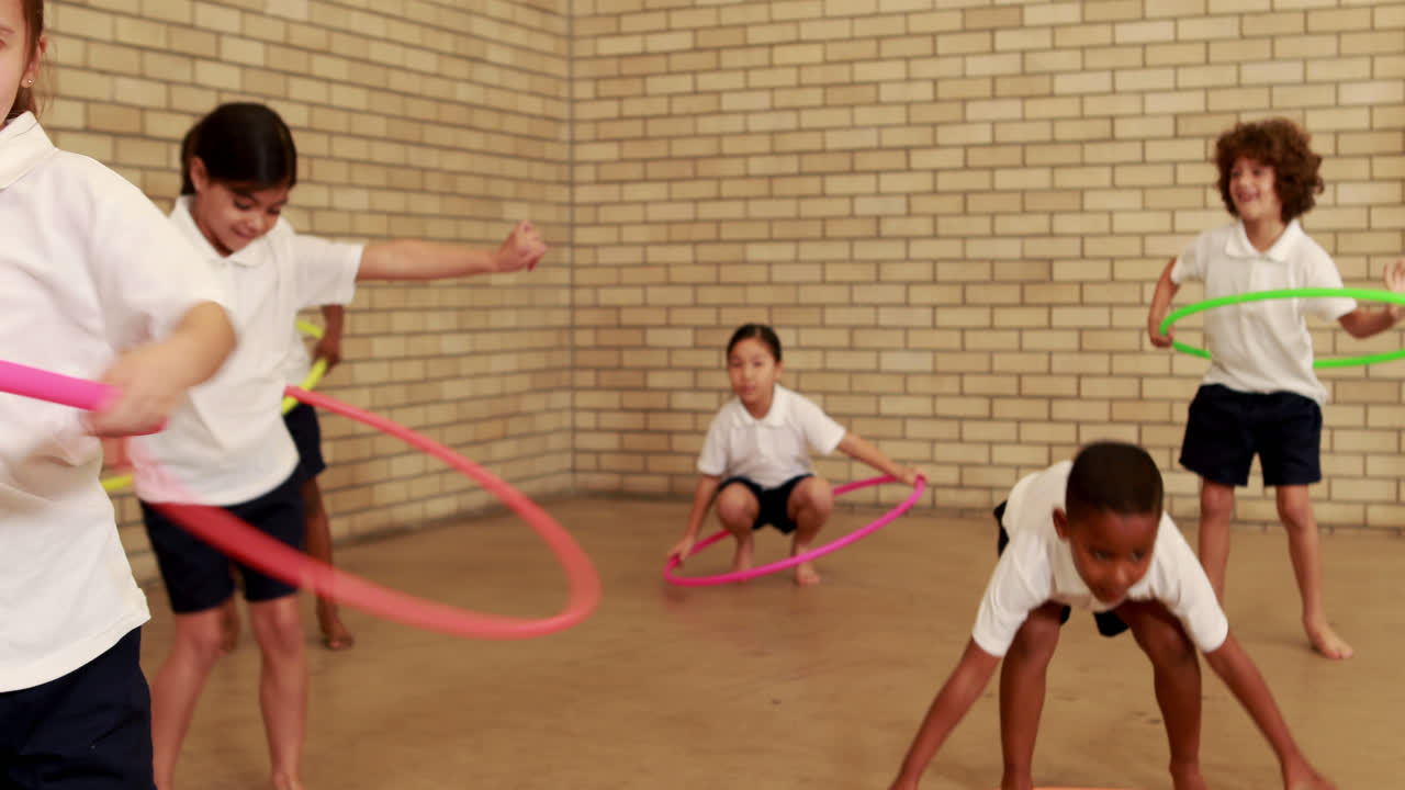 Premium stock video - Pupils exercising with hula hoop