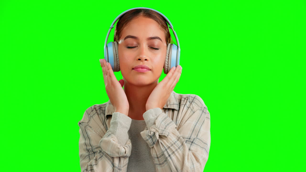 Premium stock video - Green screen, headphones and woman listening to