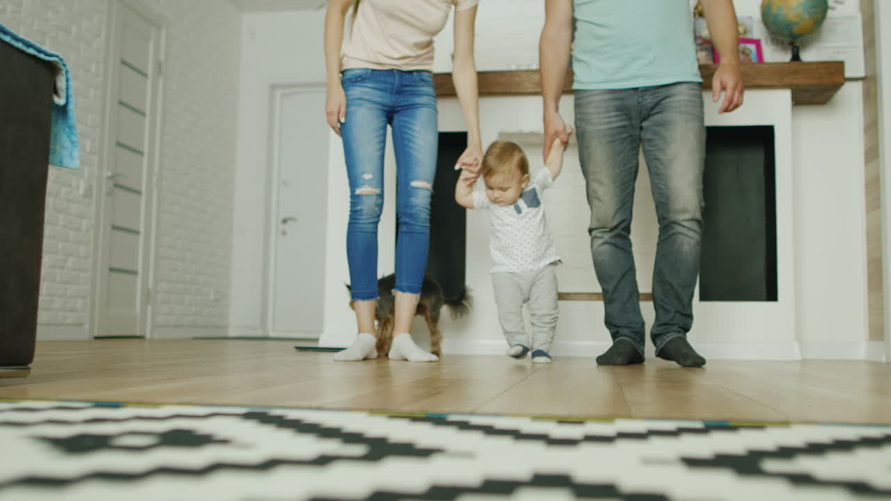 Premium stock video - Parents are taught to walk a little boy at home