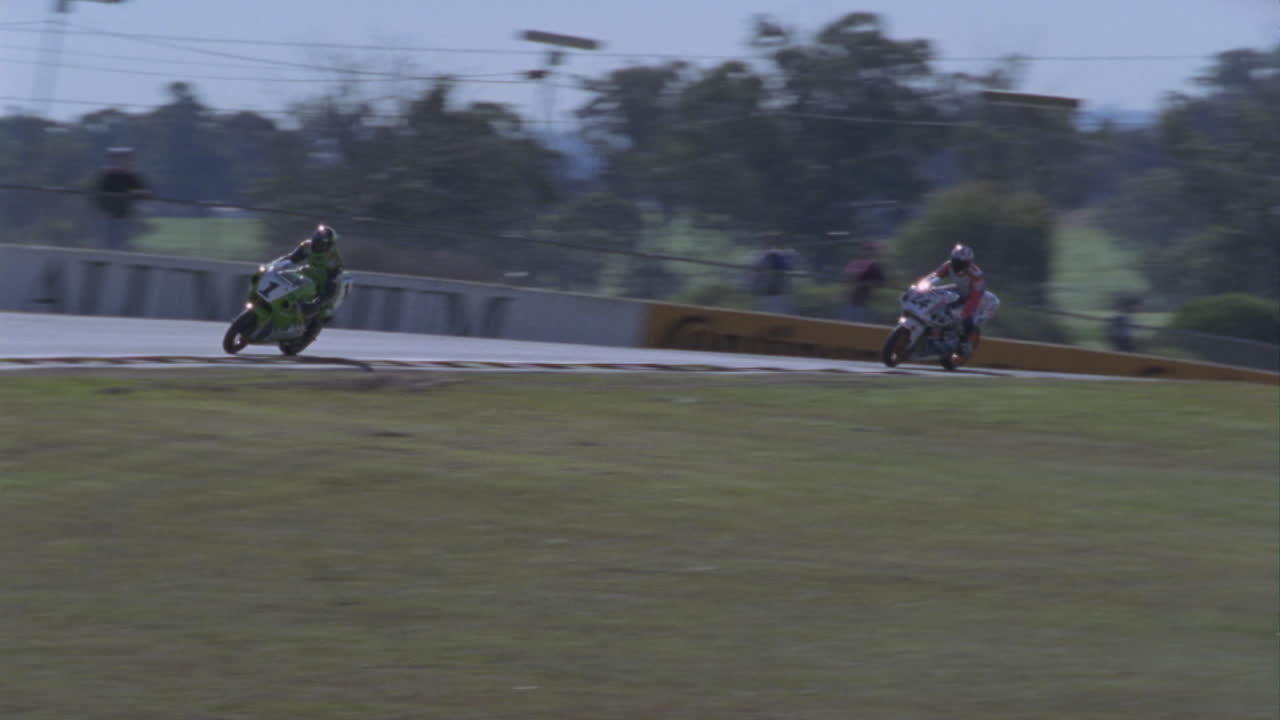 Motorcyclists race around a track spectators watch Premium Stock Video ...