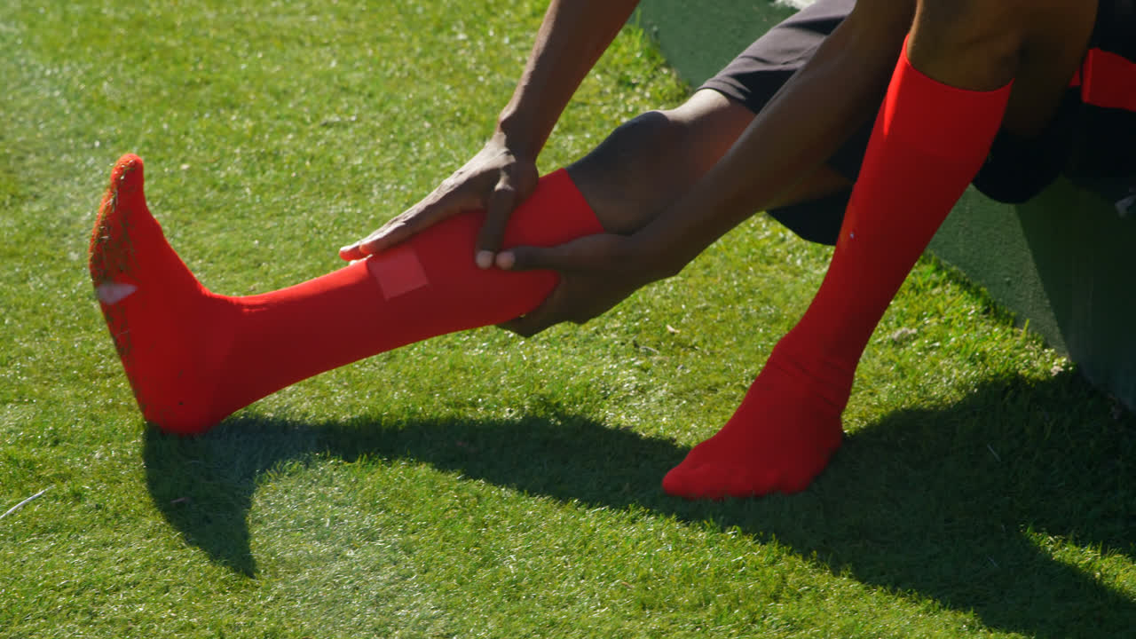 Premium stock video - Football player massaging his leg 4k