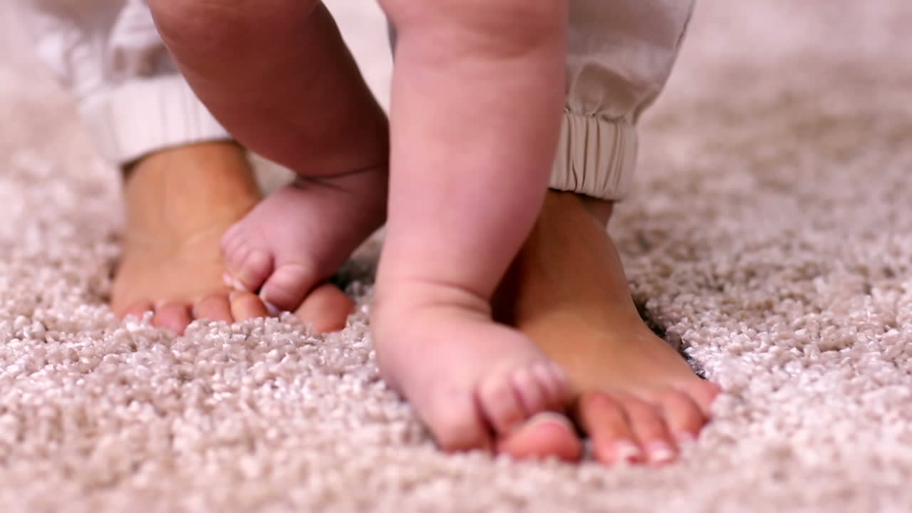 Premium stock video - Baby walking on mothers feet