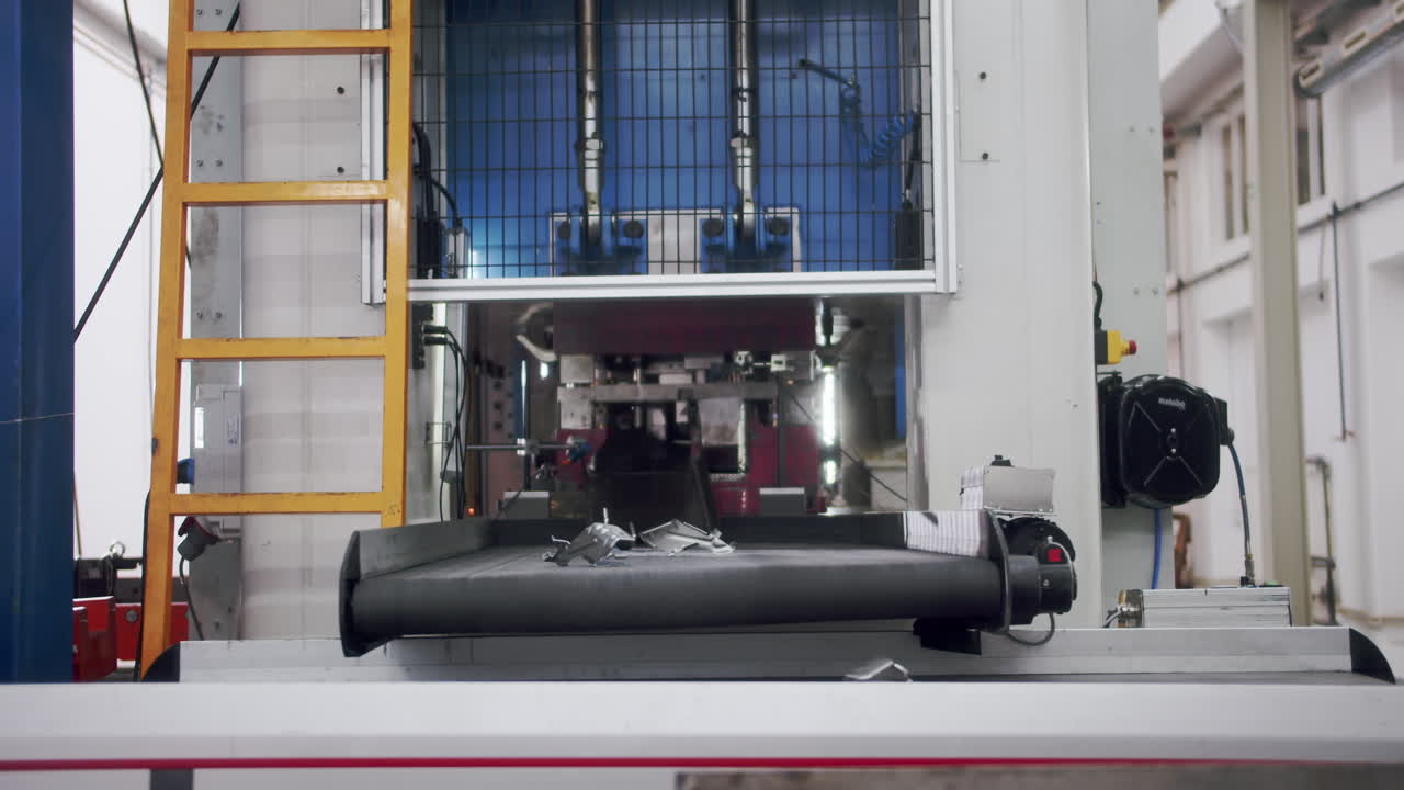 Car parts falling on a conveyor belt after being molded with a big ...