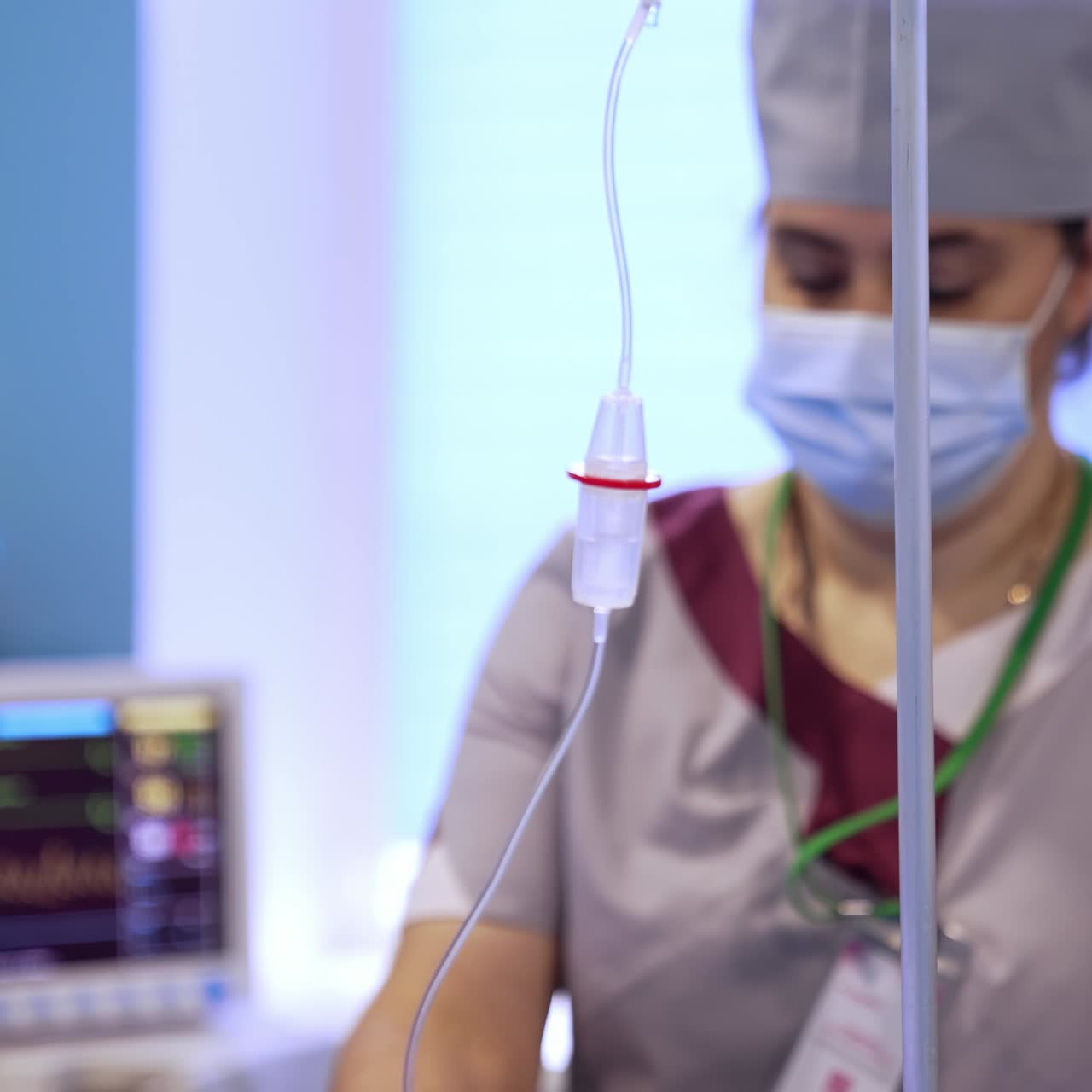 Caucasian nurse working in the surgery room. Female medic touching the drop counter. Close up ...