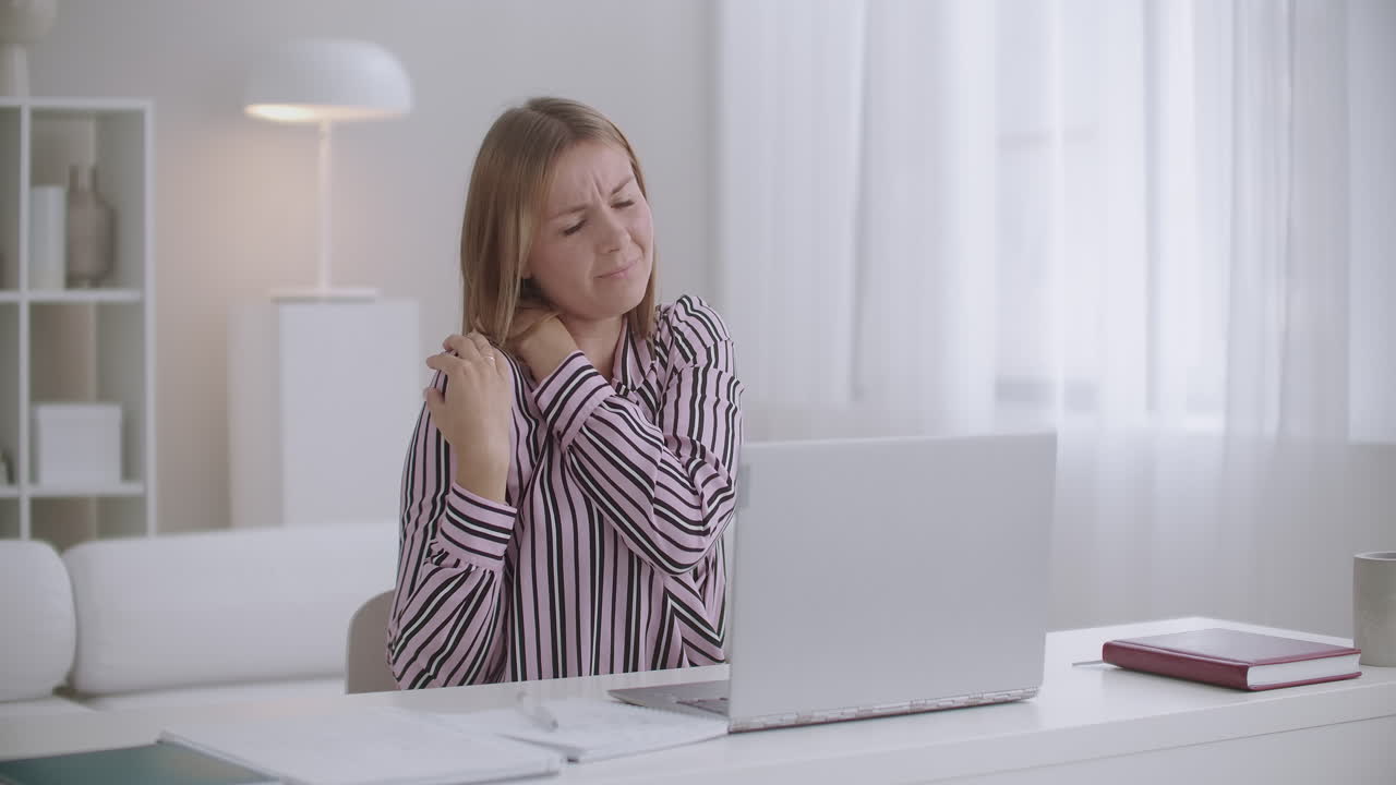 Premium stock video - Young woman is feeling sharp ache in neck and ...
