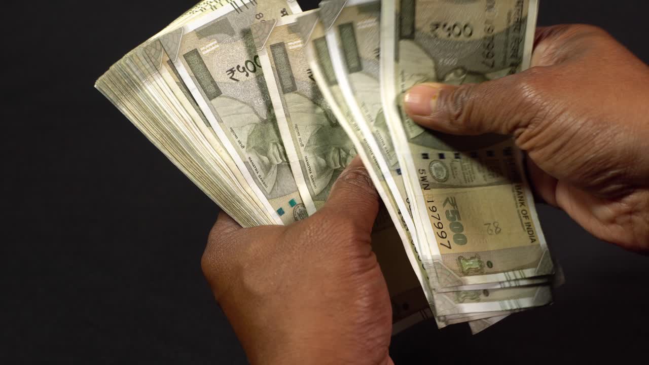 Premium stock video - A man counting indian rupees