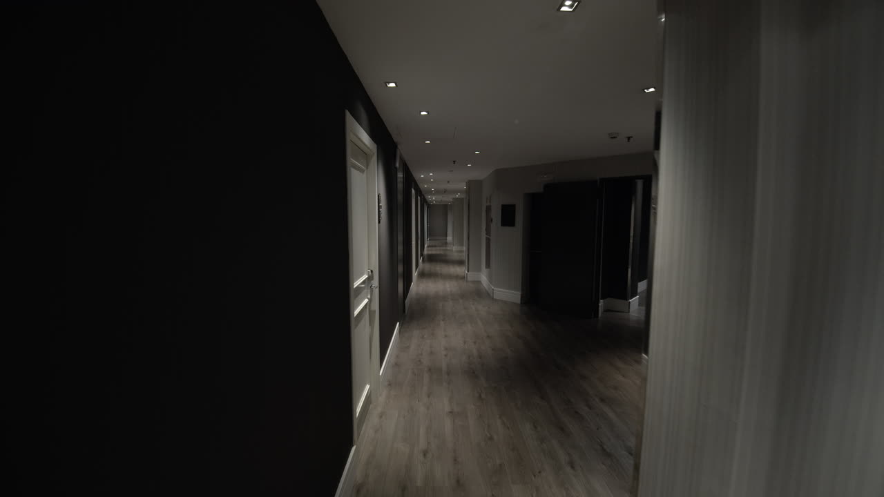 Premium stock video - Hotel guest walking along the empty hallway