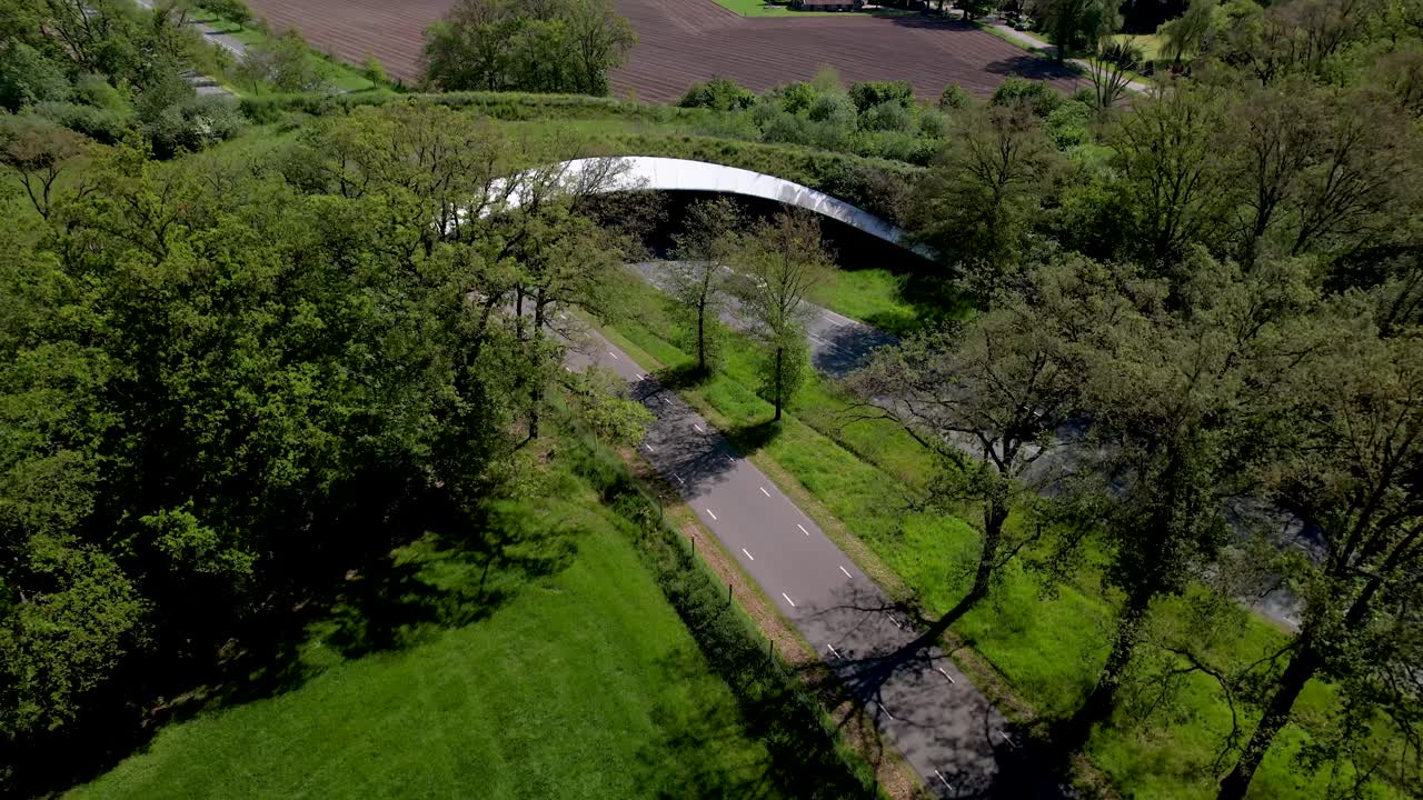 Descending aerial closing in on large wildlife crossing forming a safe ...