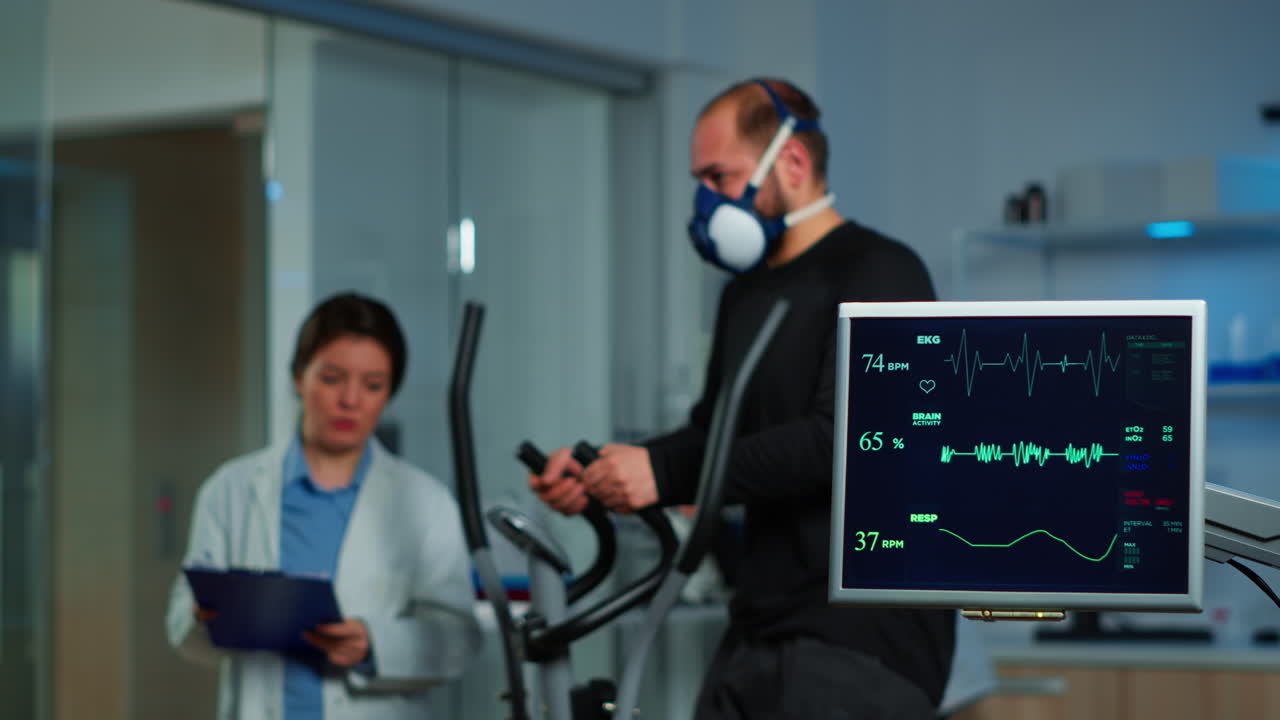 Premium stock video - Team of medial researcher monitoring vo2 of man