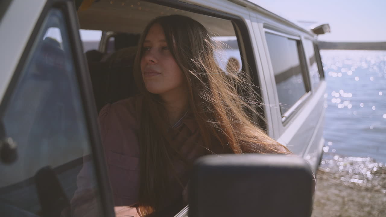 A Young Long Haired Red Haired Girl Sitting In A Caravan By A Lake ...
