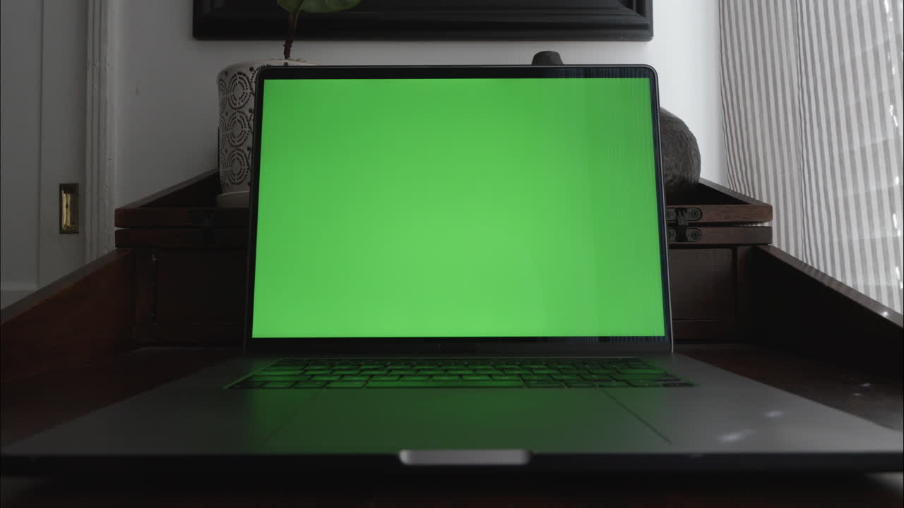 Premium stock video - Laptop computer on home office desk with green ...