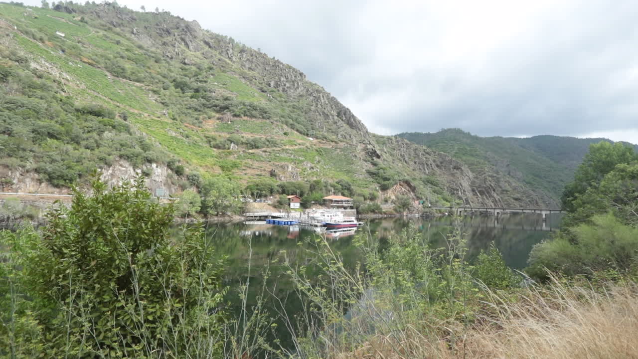 Premium stock video - Boats float on a calm river surrounded by lush ...