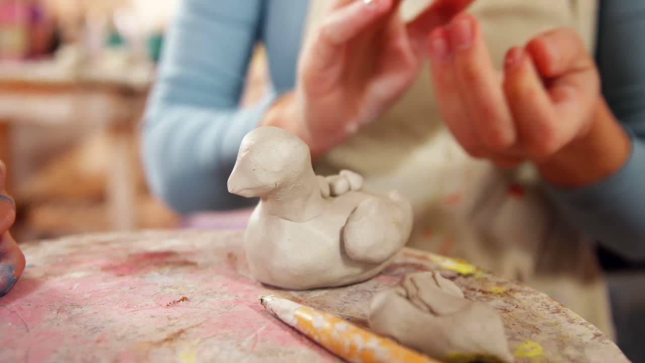 Premium stock video - Mother and daughter making a toy from clay
