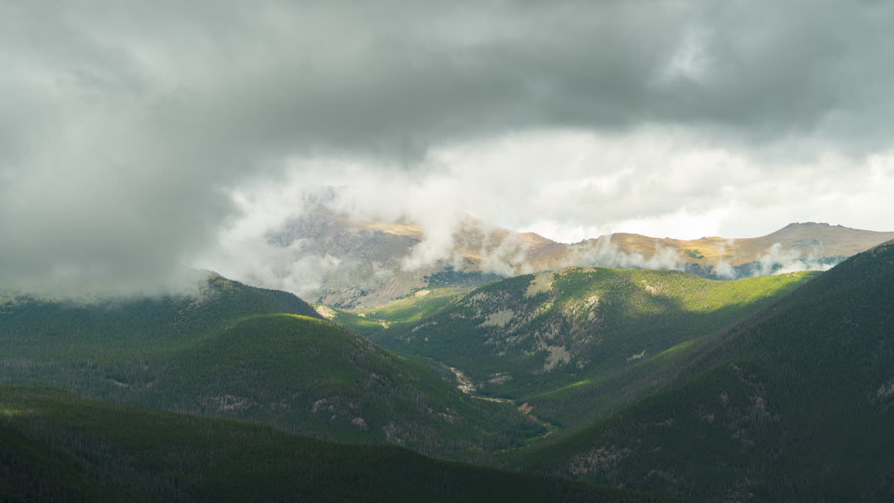 Sun shines through the mountain clouds in Colorado | Premium Stock ...