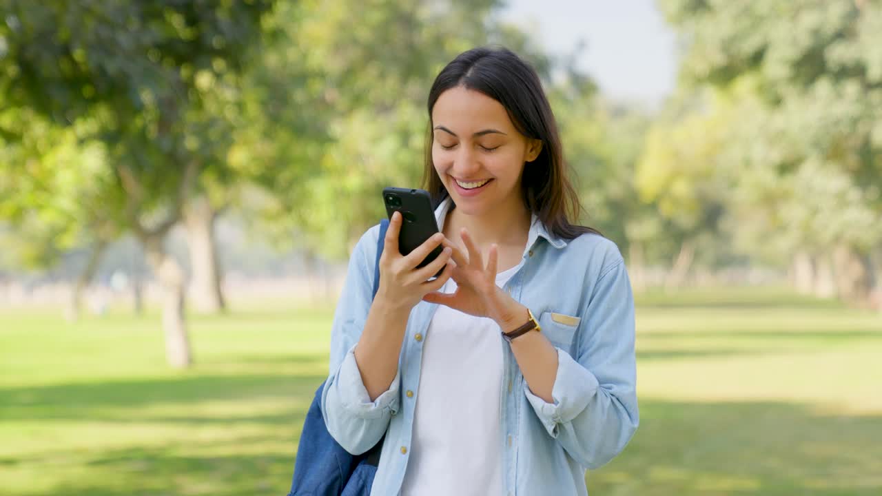 Happy indian girl scrolling through phone Premium Stock Video Footage