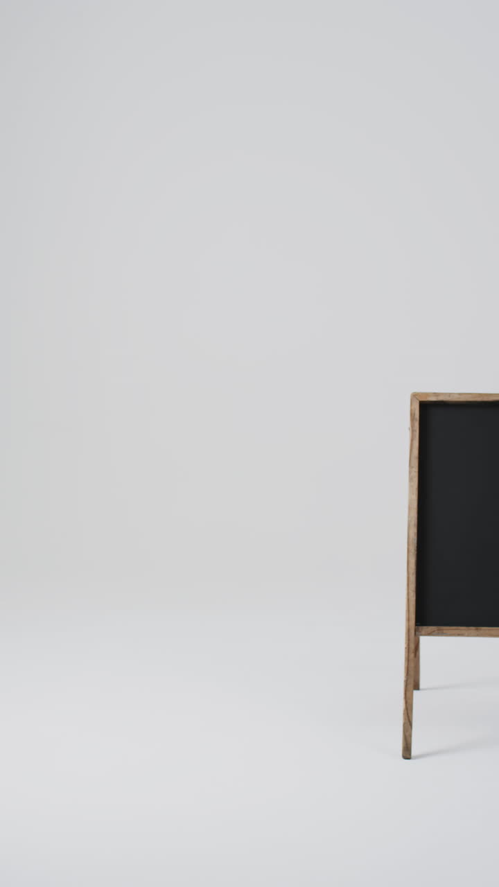 Vertical video of blackboard sign on wooden stand with copy space on ...