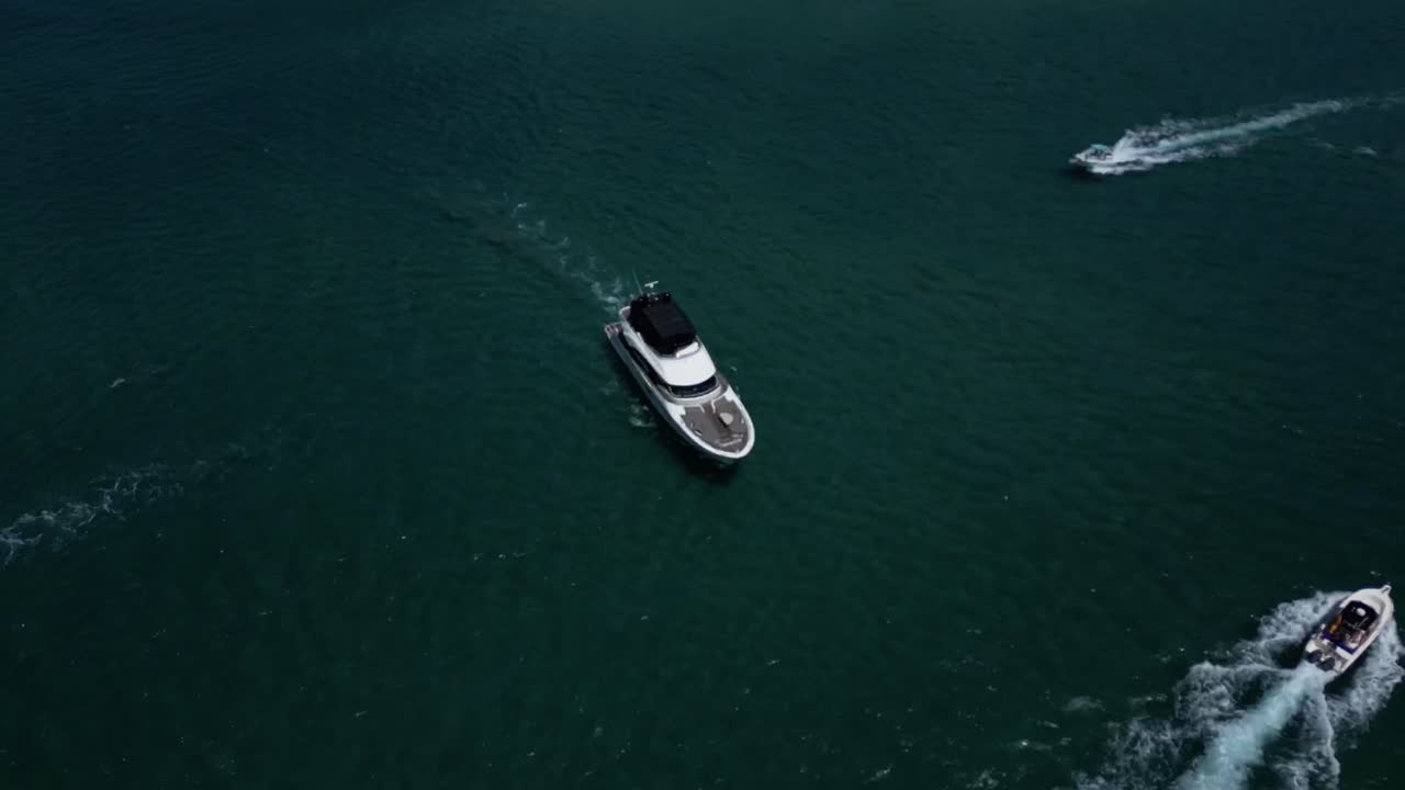 A Luxury Yacht Moving Slowly Navigating Between Smaller Boats On A ...