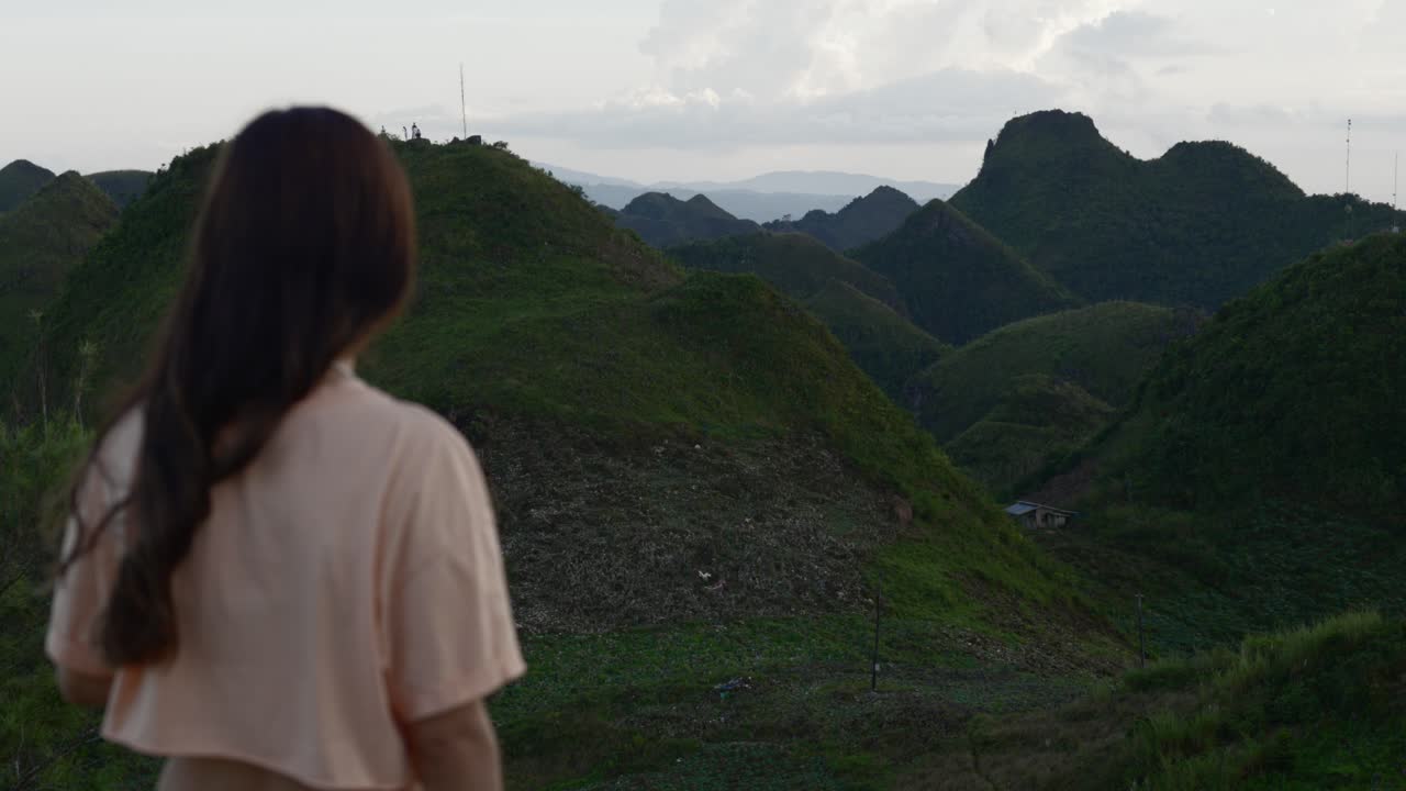 Premium stock video - Medium telephoto view of woman staring out across ...