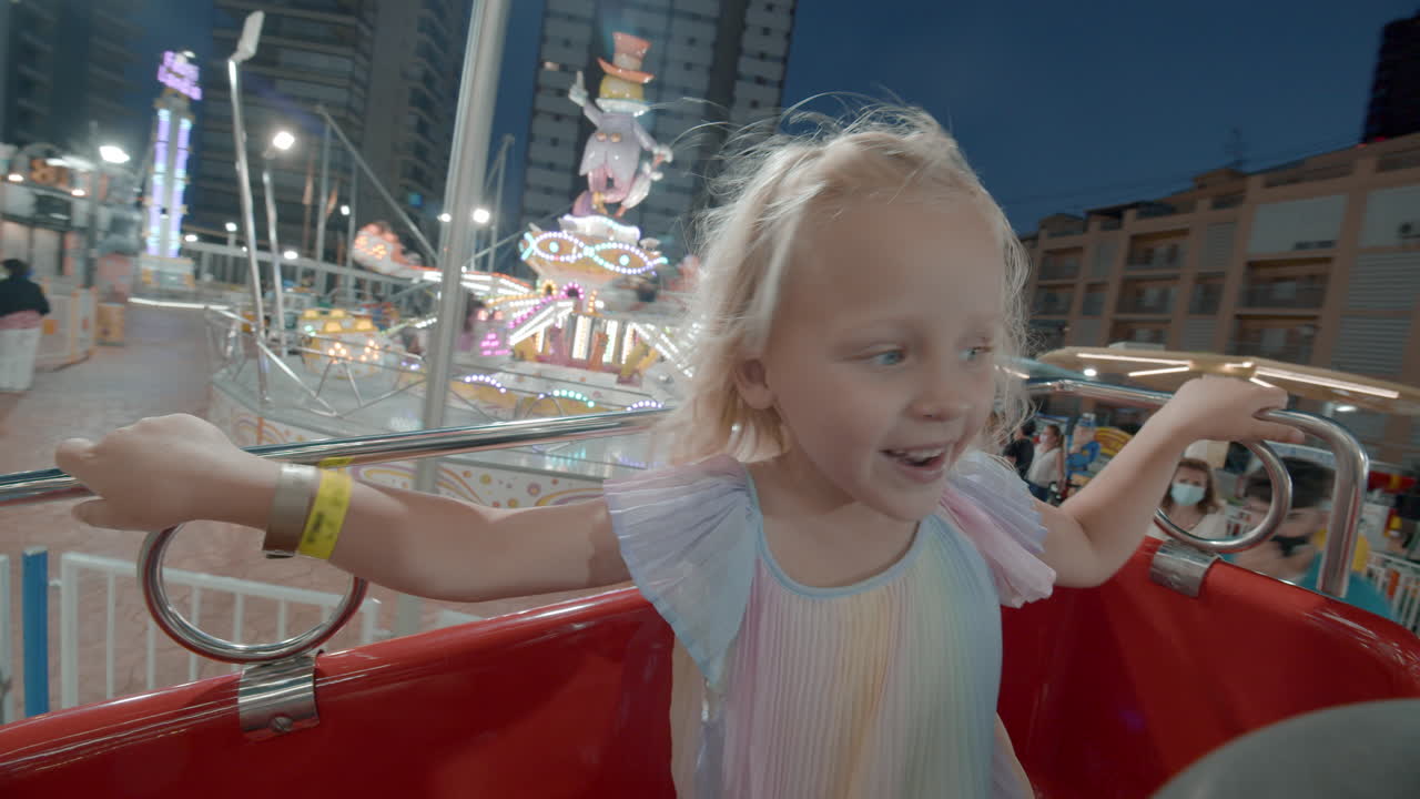 Premium stock video - Happy girl in merry-go-round in the evening