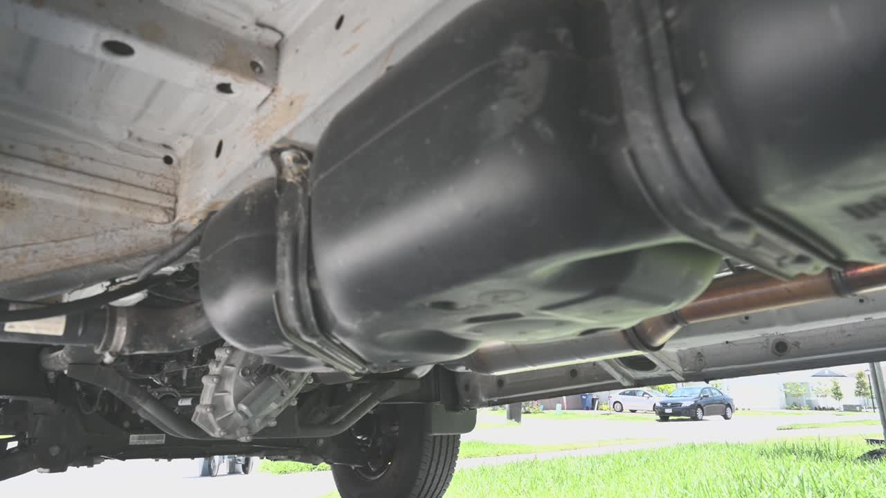 Premium stock video - Mechanicals under a van that focuses on the gas tank