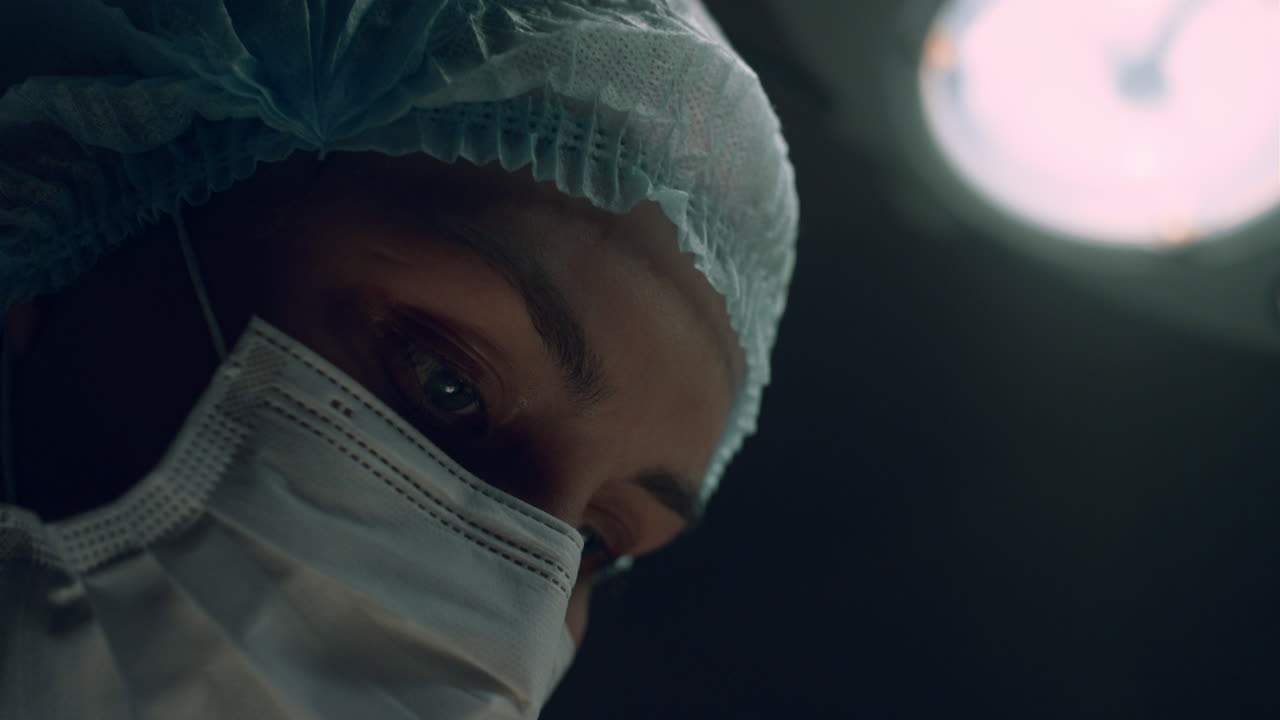Portrait surgeon performing operation in dark hospital intensive care ...