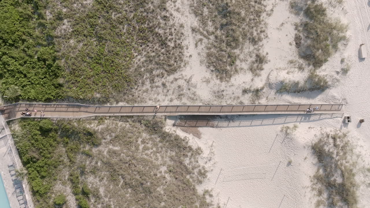 Aerial top-down view of a long boardwalk stretching across the dunes ...