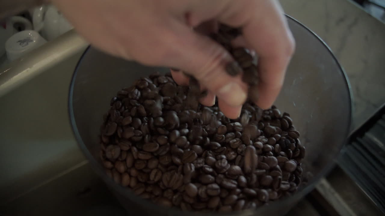 Premium stock video - Close up of hand mixing coffee beans slow motion