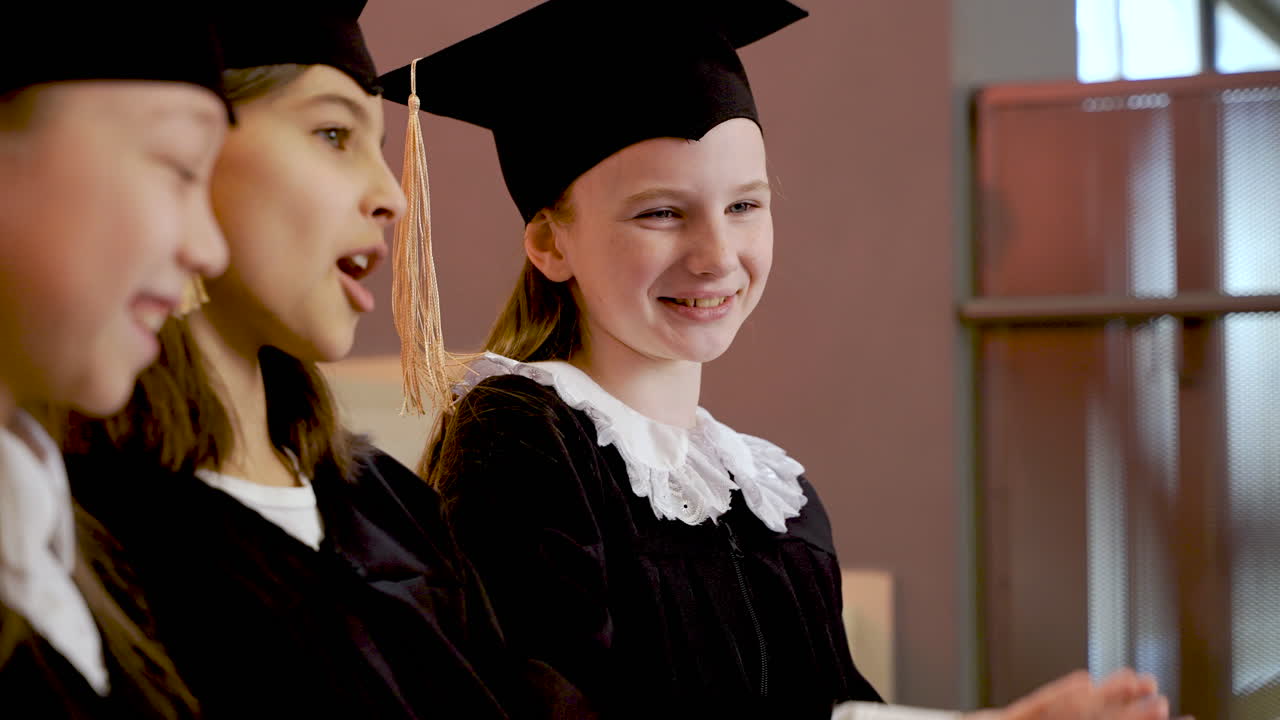 Three Happy Little Girls In Cap And Gown Playing And Laughing Together ...