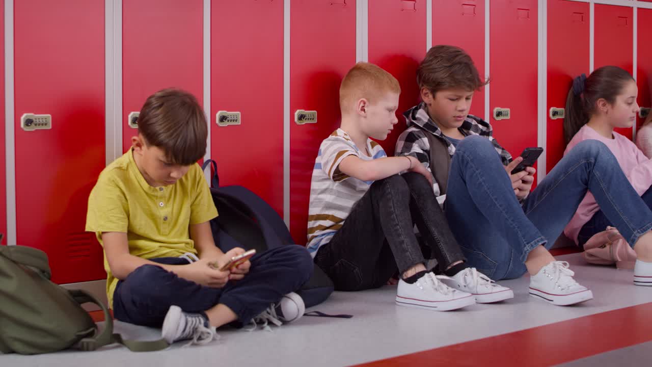 Tracking video of group of children using smartphone at school ...