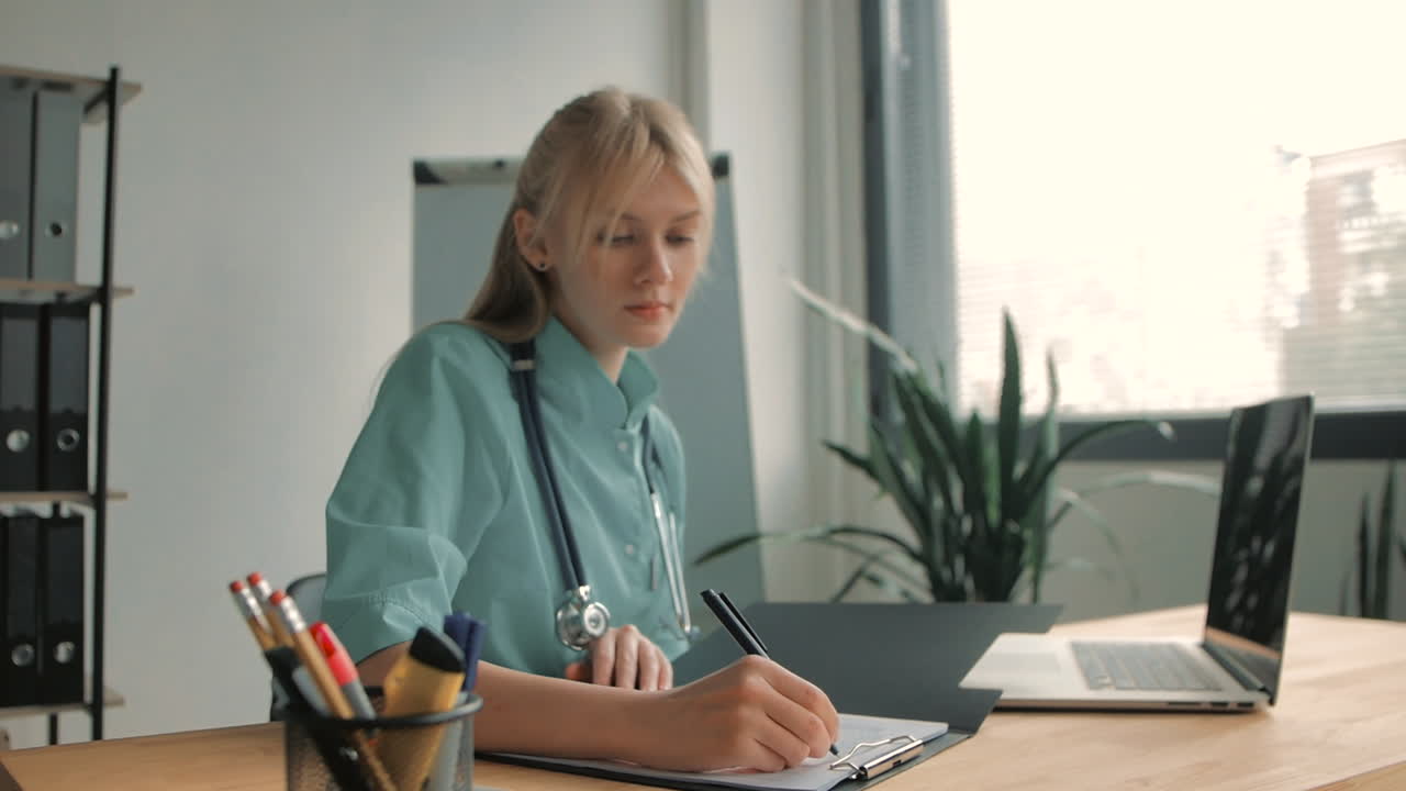 Young Pretty Blonde Female Nurse Care-taker Working At The Office Desk ...