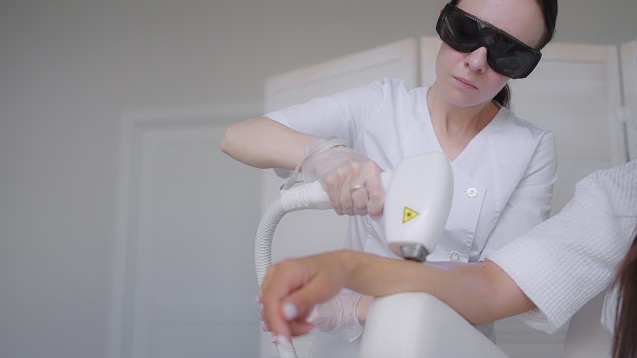 Close-up. laser hair removal under the armpit of a beautiful girl in a ...