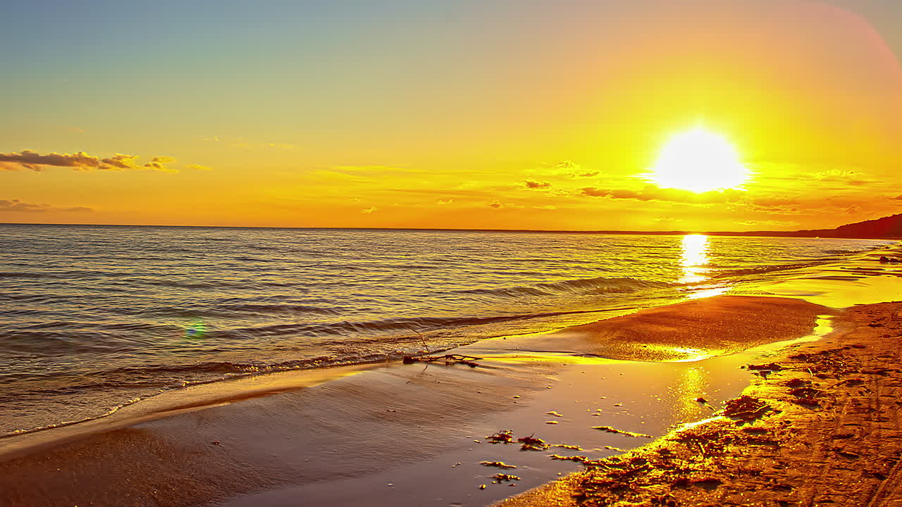 Bright yellow sunrise over sandy beach and ocean water, fusion time ...