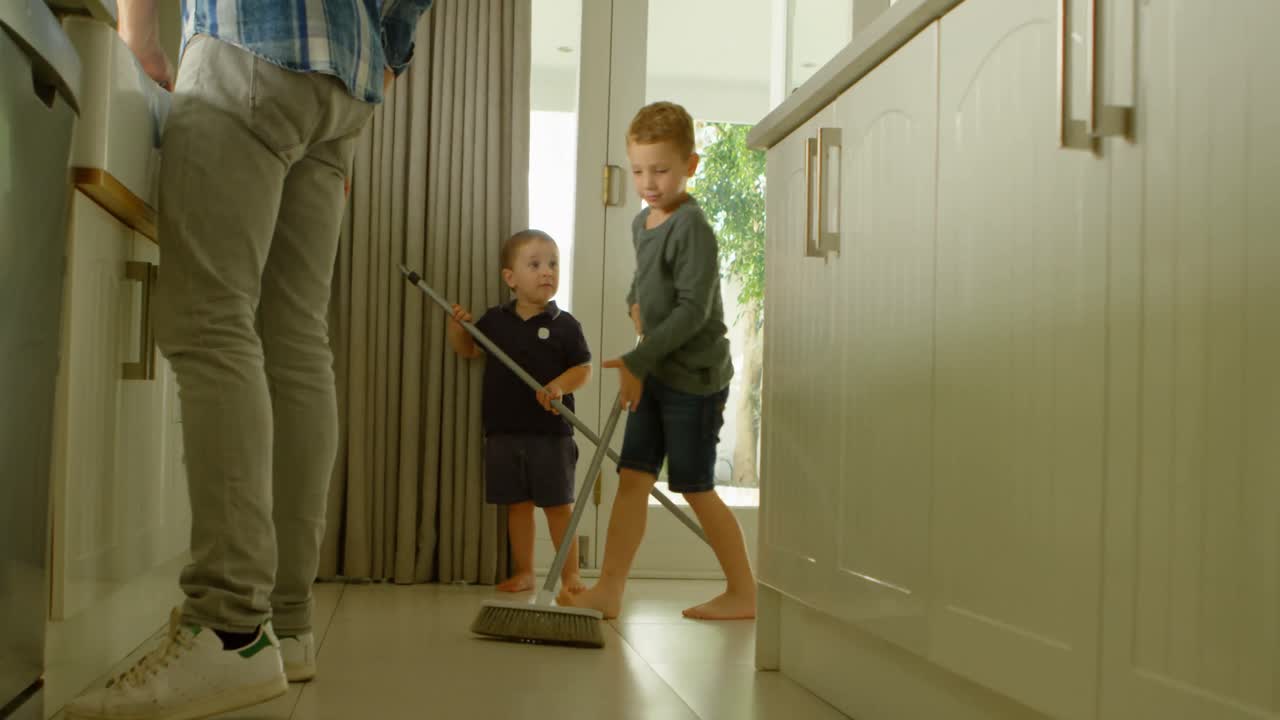Father and siblings cleaning kitchen 4k | Premium Stock Video Footage