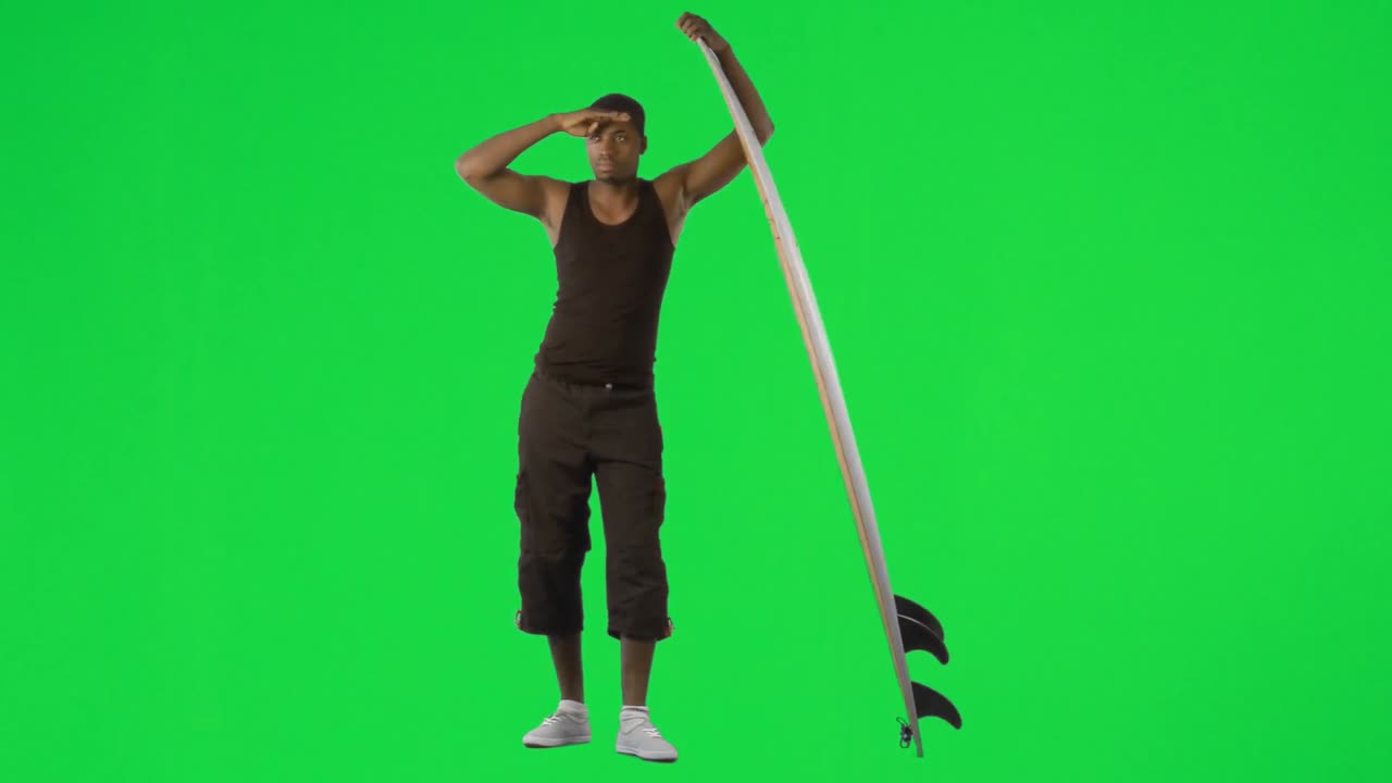 Premium stock video - Ethnic boy with a surfboard against green screen