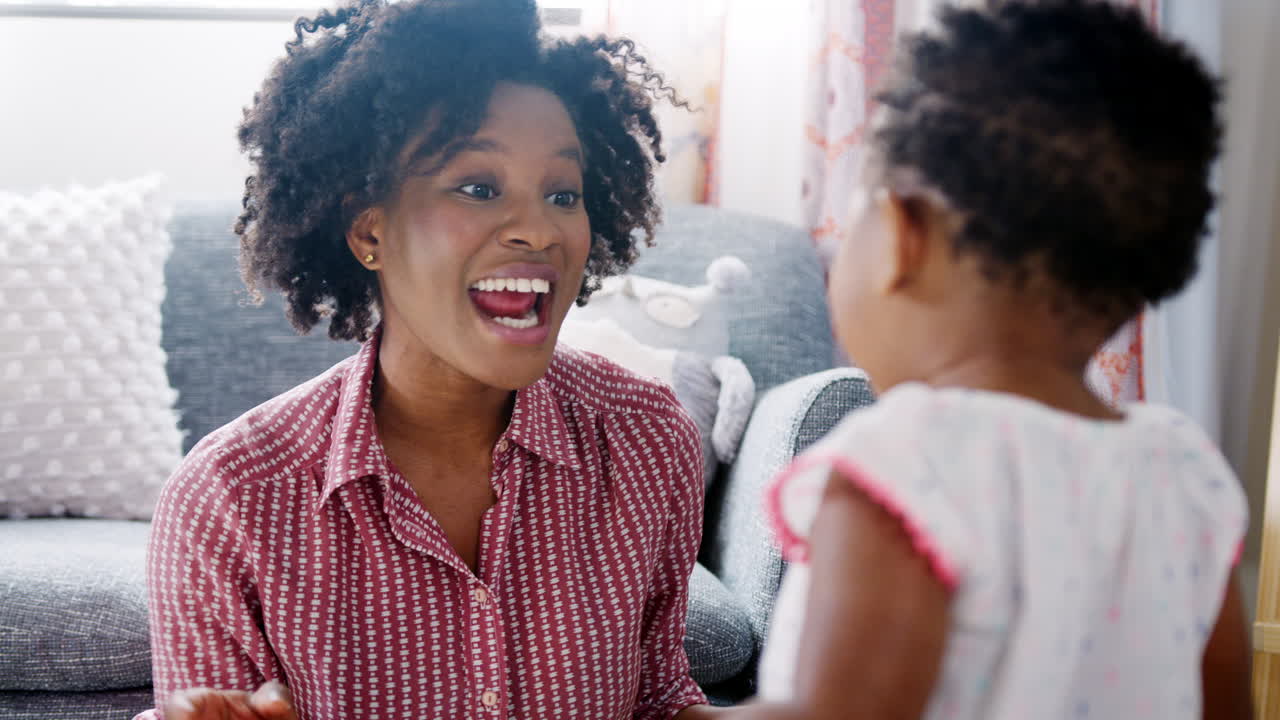 Premium stock video - Mother singing song to baby daughter at home