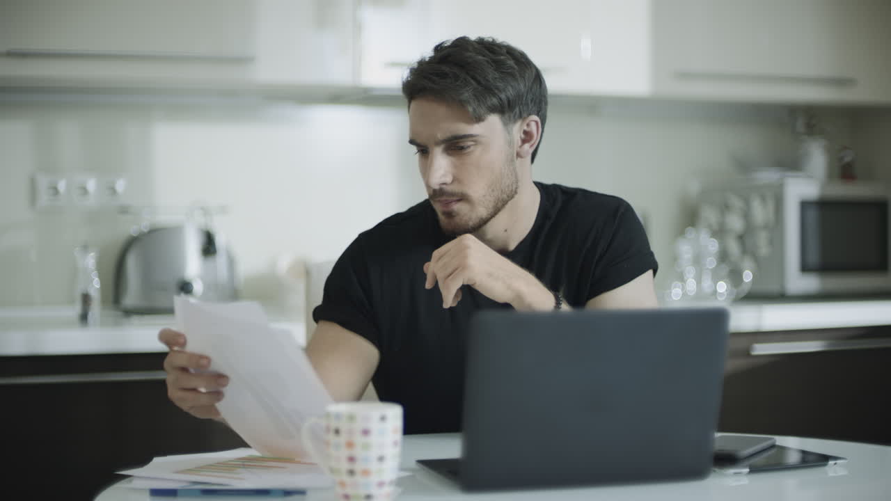 Premium stock video - Businessman looking paper at home workplace ...