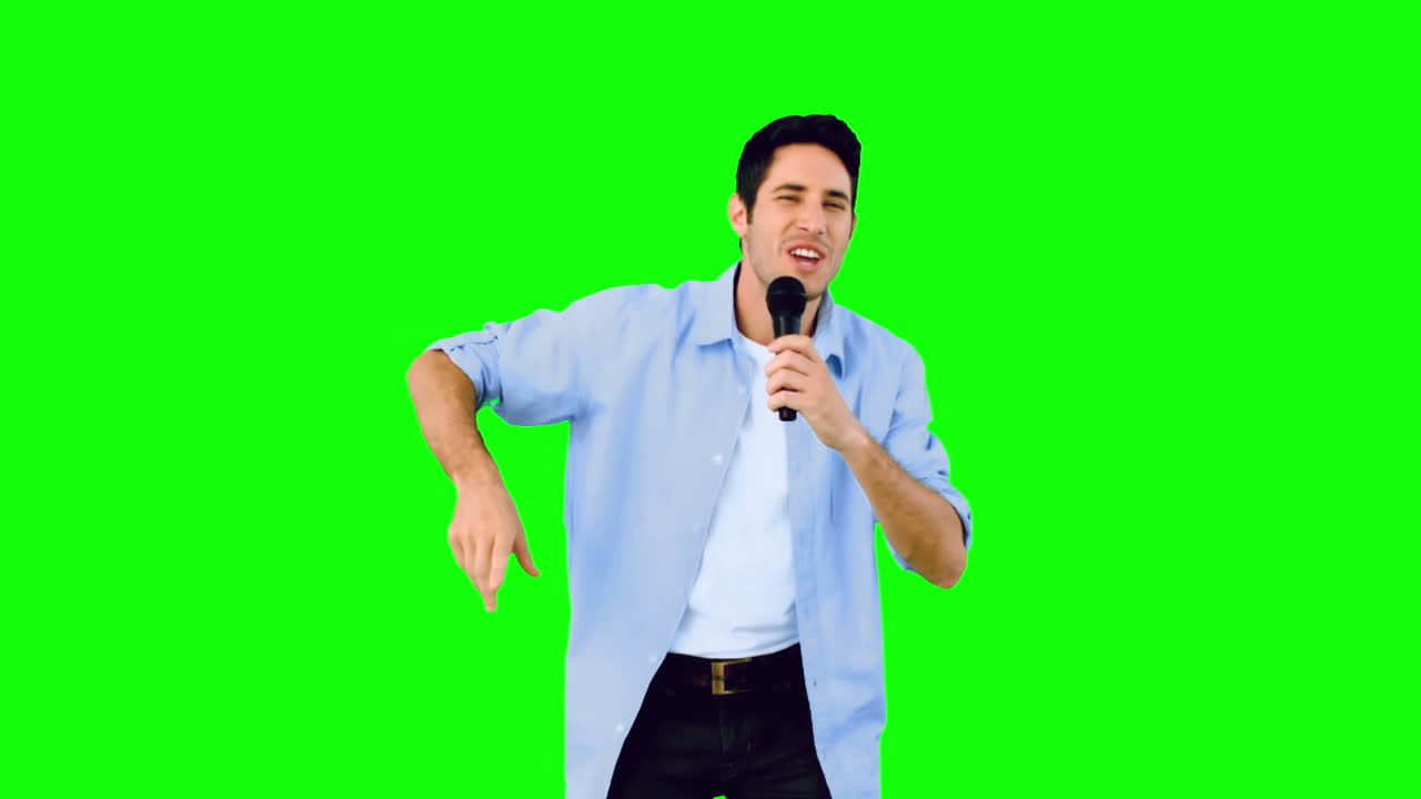 Premium stock video - Man singing into microphone and dancing on green ...