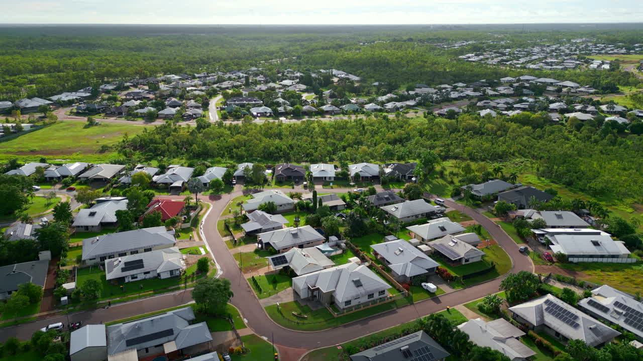 Aerial drone of tropical suburb neighborhood surrounded by lush forest ...