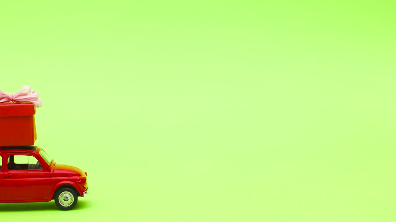 Little red vintage car driving red gift on the roof on green screen ...
