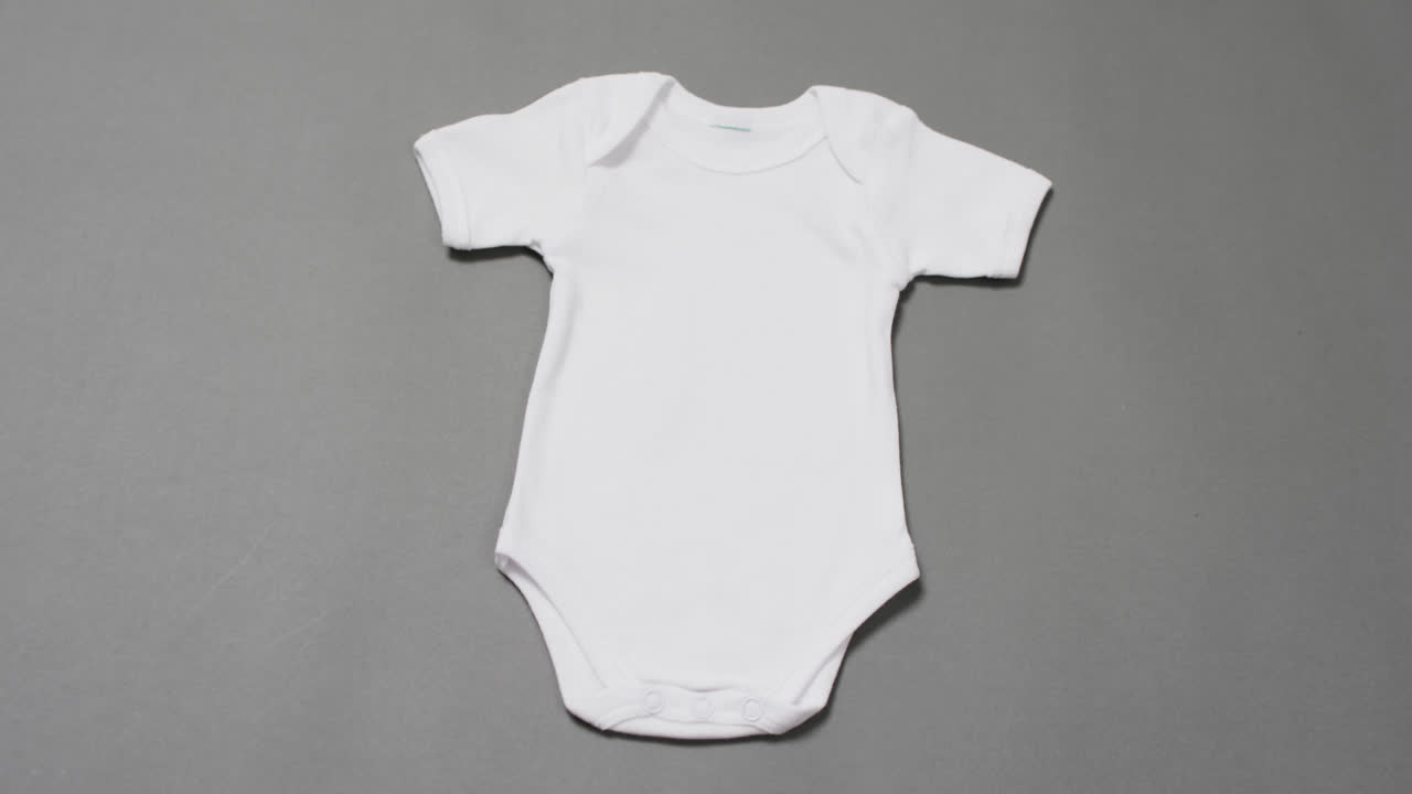 Premium stock video - Video of white baby grow with copy space on grey ...