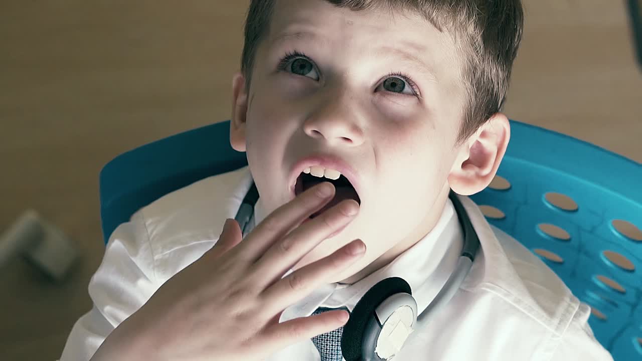 Premium stock video - Cu slow motion schoolboy sits at the table in ...