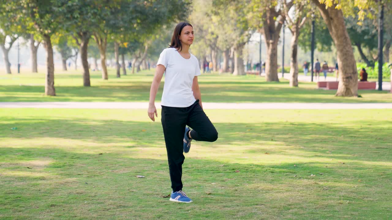 Indian woman doing leg stretching exercise in a park in morning Premium ...