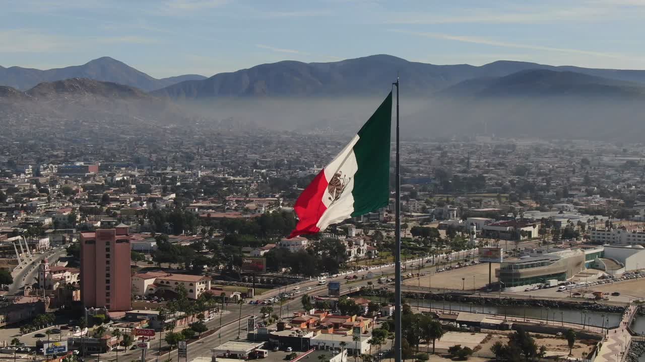 Premium stock video - Mexican flag waving over the city of ensenada