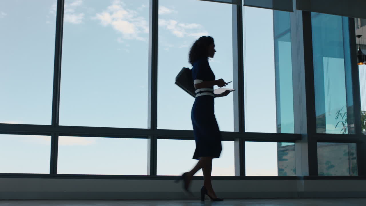 Premium stock video - Business woman using smartphone walking through ...