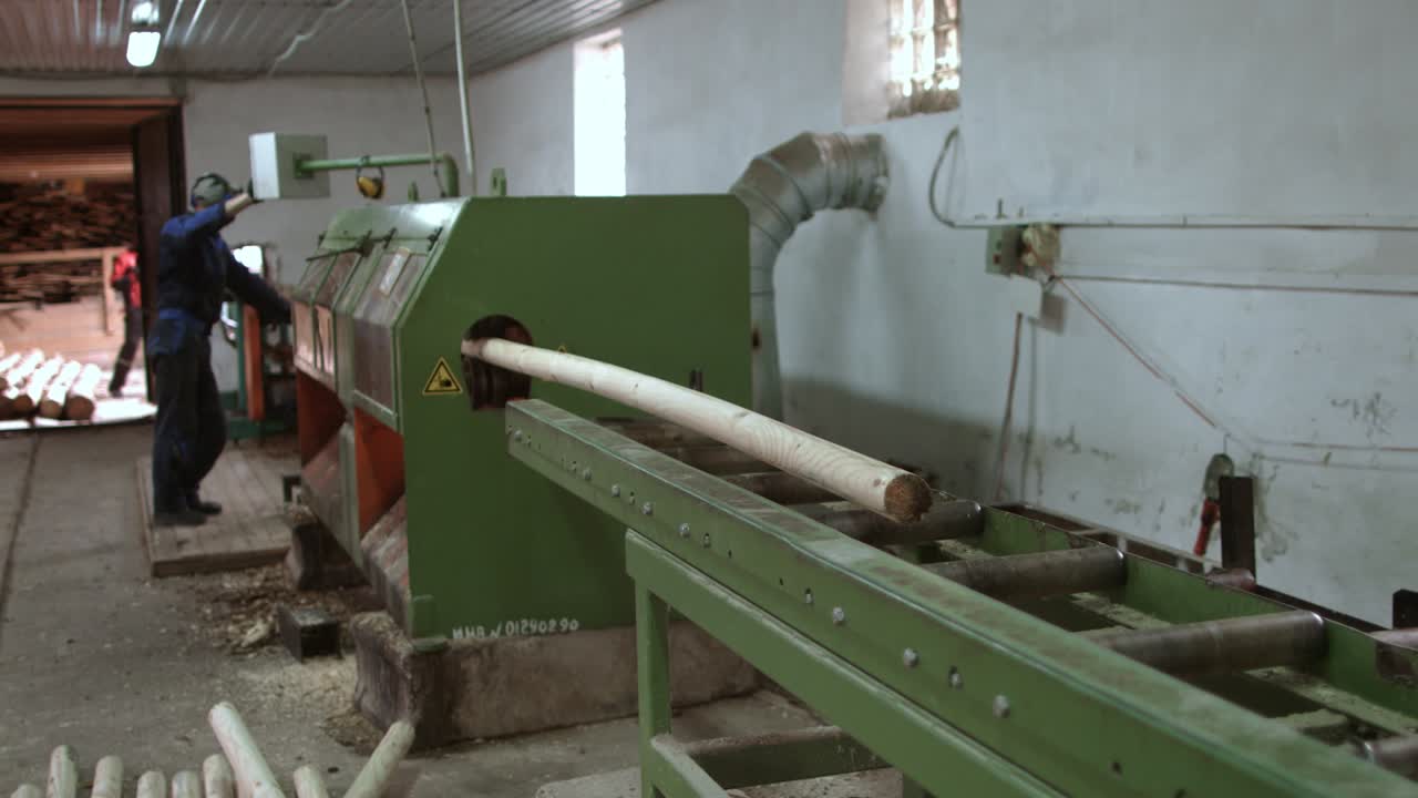 Man controlling process of woodworking at cylindering machine. Timber ...