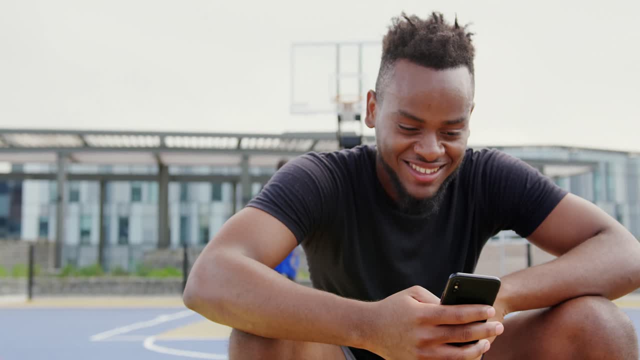 Basketball player using mobile phone 4k | วิดีโอสต็อกแบบ พรีเมี่ยม